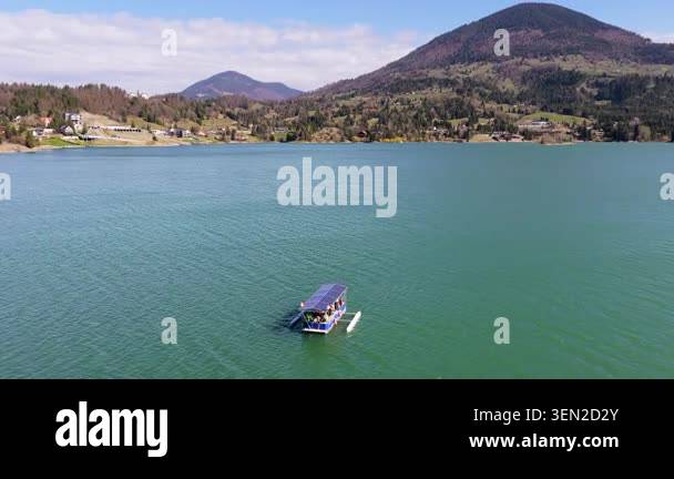Aerial drone view of a small passenger boat moving across the Colibita ...