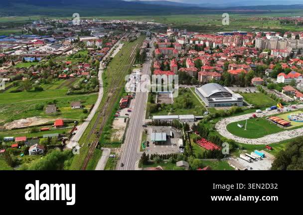 High-altitude aerial view of a town with road, railway and a sports ...