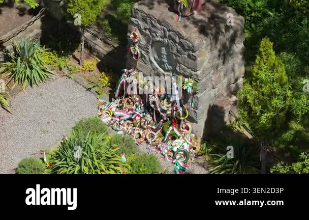 Overhead aerial view of a stone memorial with floral wreaths in a ...