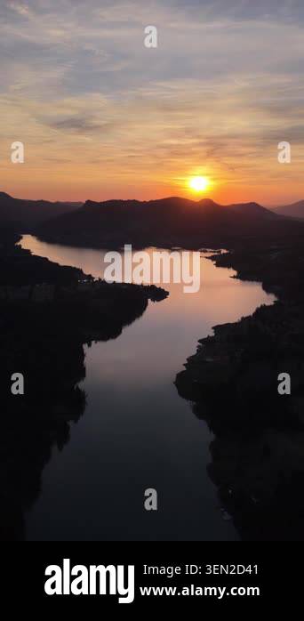 Aerial drone view of Colibita lake partially visible between darkened ...