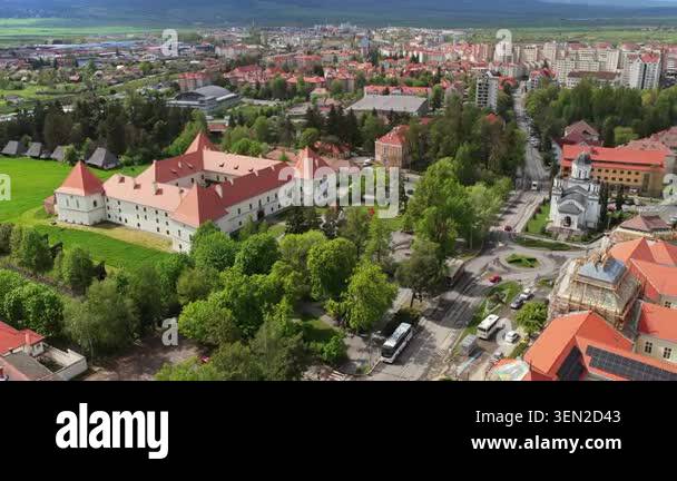 Aerial drone view of a white castle with red roof and towers above a ...