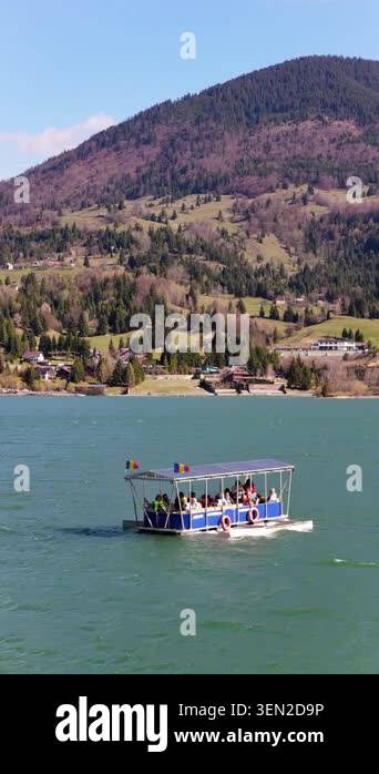 Aerial drone view of a small passenger boat moving across the Colibita ...