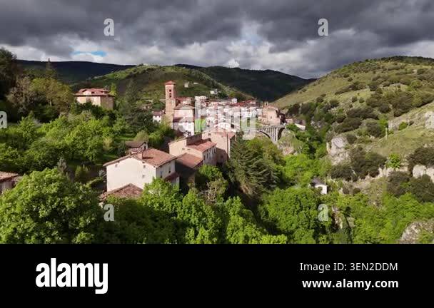 Aerial panoramic shot approaching a picturesque mountain village with a ...