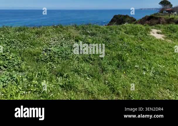 Aerial panoramic reveal shot of a hidden sandy beach and rocky ...