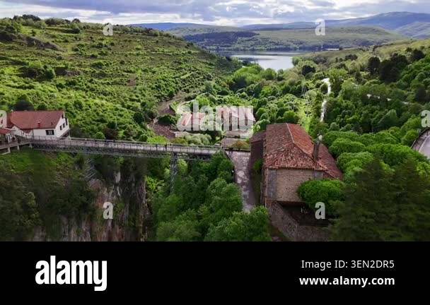 Aerial panoramic orbit shot of a historic iron bridge and old stone ...