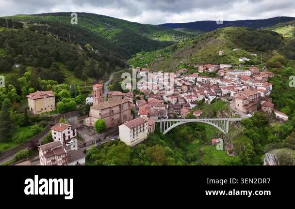 Aerial panoramic view approaching a picturesque mountain village with a ...