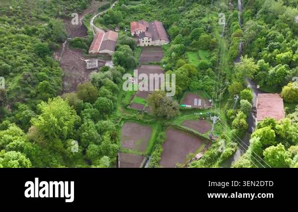 Aerial tilt up reveal shot of traditional vegetable gardens and rural ...