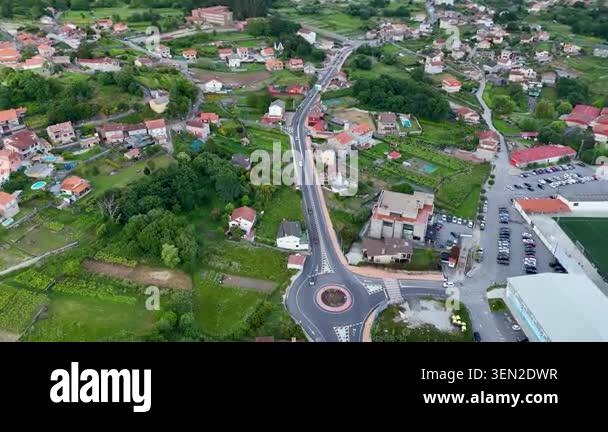 High angle drone shot flying over a rural landscape with houses, green ...