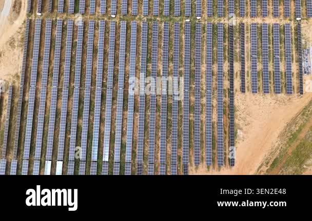 Expansive aerial view flying over a large solar power station. Rows of ...