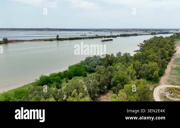 Aerial view of a large merchant vessel navigating the Guadalquivir ...