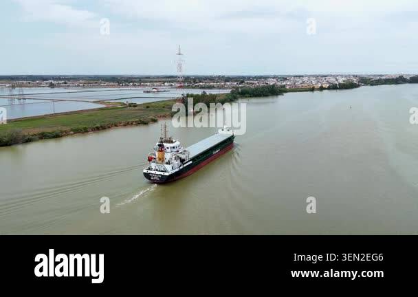 Aerial footage of a large freighter navigating the Guadalquivir river ...