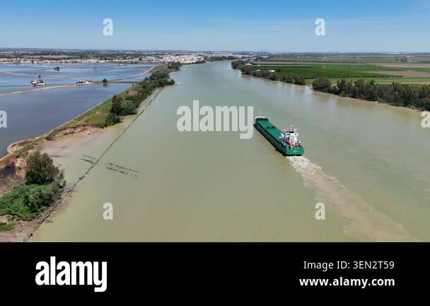 Aerial drone view of a large barge navigating the muddy waters of the ...