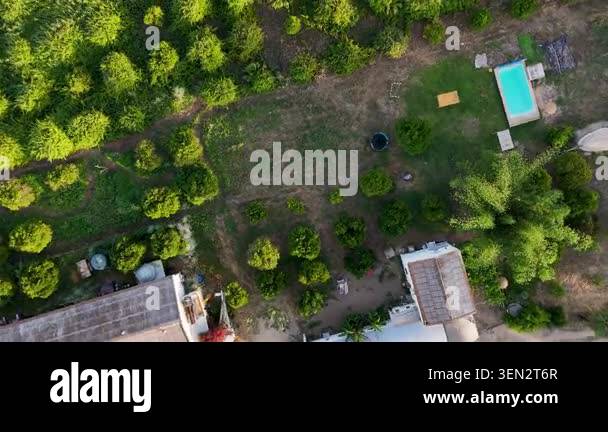 Drone's aerial perspective flying over a rural house with a garden ...