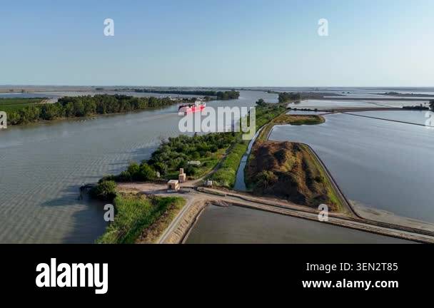 Aerial view of a large red container ship navigating the Guadalquivir ...