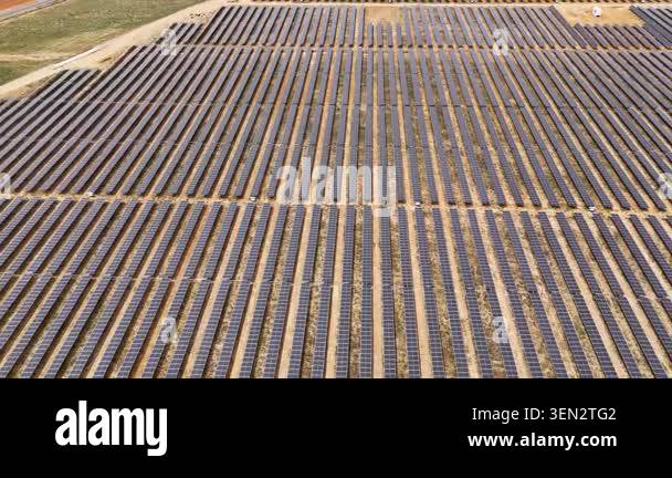 Aerial view flying over a large solar farm with photovoltaic panels ...