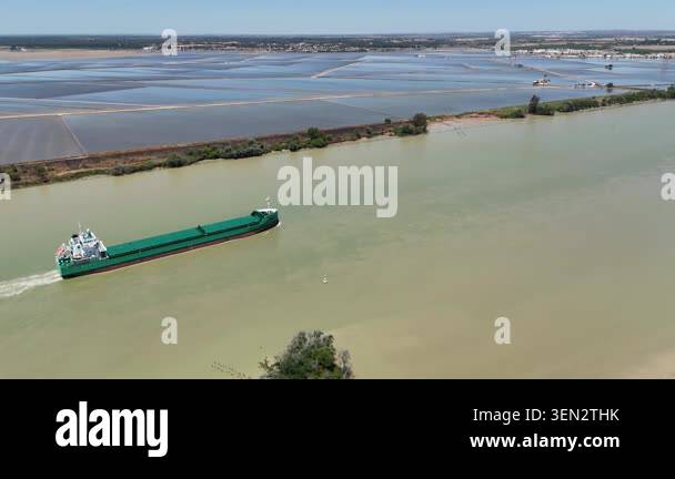 Aerial view of a large green freighter sailing on the Guadalquivir ...