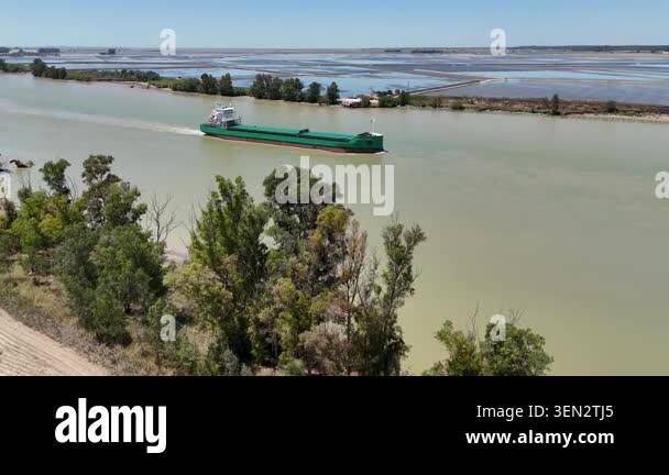Large green commercial cargo ship navigating the Guadalquivir river in ...
