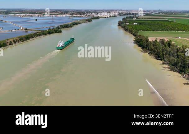 Aerial view of a large cargo ship navigating the Guadalquivir river ...