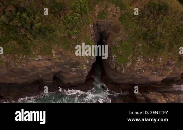 Rugged coastal cliffs and sea, aerial drone survey captures eroded rock ...