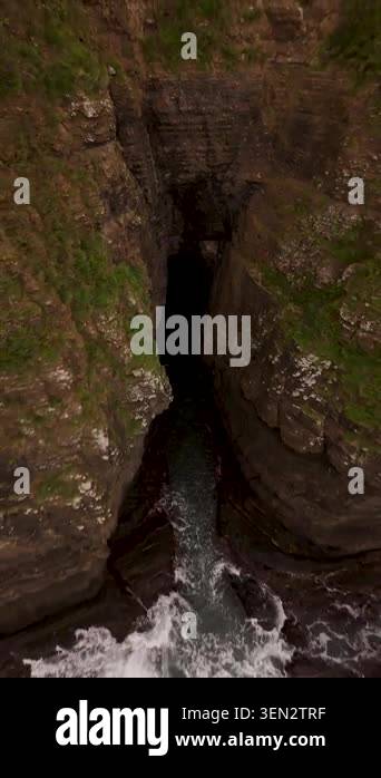 Rugged coastal cliffs and sea, aerial drone survey captures eroded rock ...