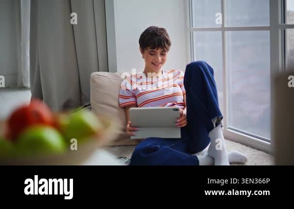 Serene woman looking tablet at carefree domestic weekend. Relaxed young ...