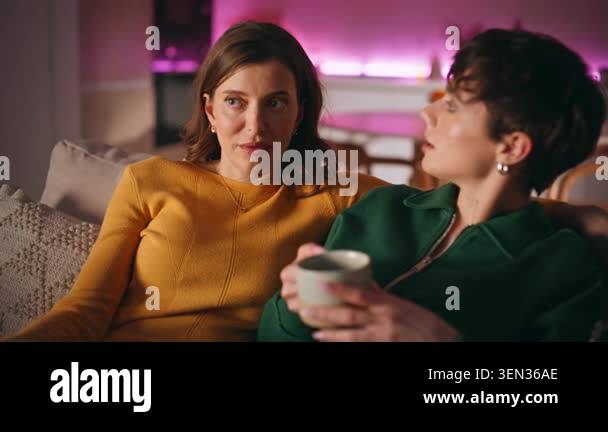 Women discussing TV show sitting comfortable home couch together ...