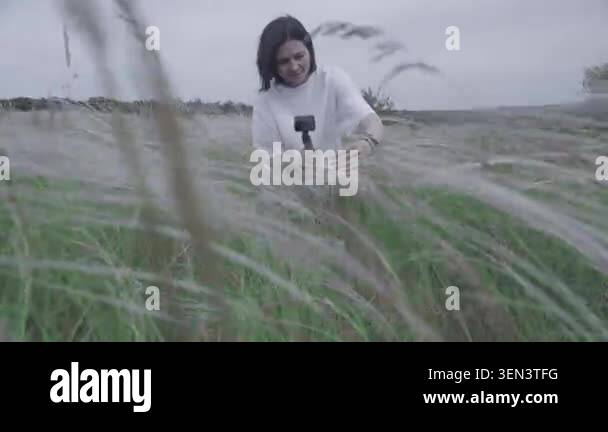 Young female travel blogger holding an action camera and filming a ...