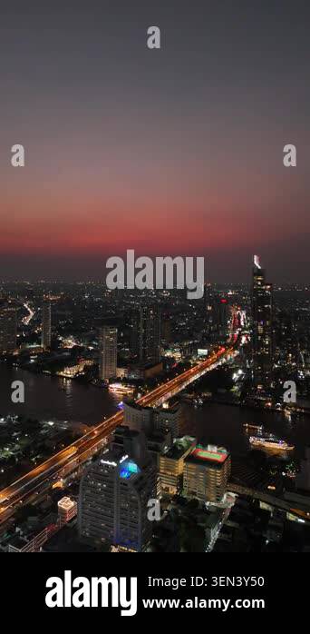Aerial view of Bangkok at dusk, showing illuminated Taksin Bridge over ...