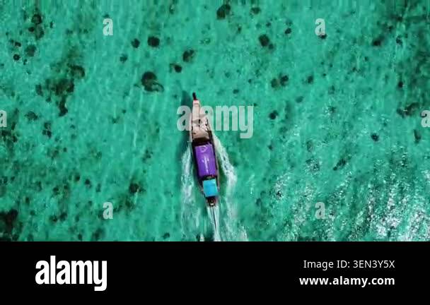 Aerial top down view of a traditional longtail boat navigating through ...