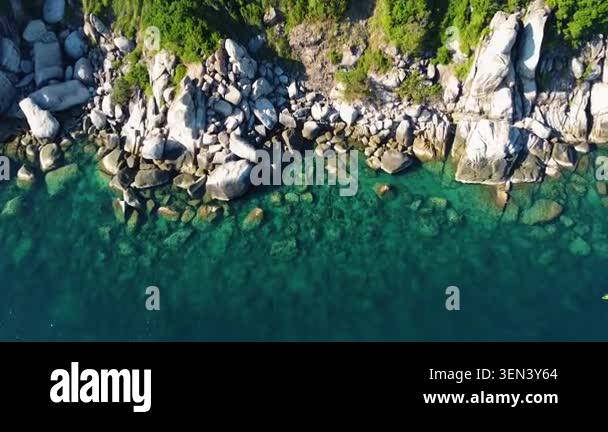 Breathtaking aerial footage moving from a rocky turquoise shoreline to ...