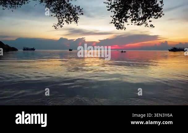 Dramatic and colorful sunset sky reflecting on the calm ocean water ...