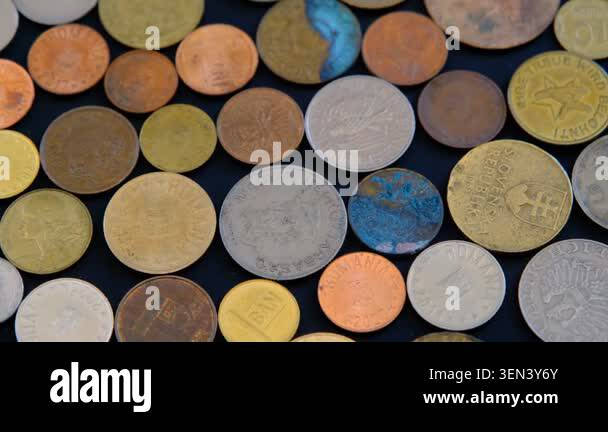 A collection of various coins, including some with symbols and designs ...
