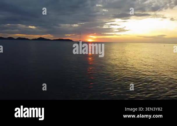 Breathtaking golden sunset reflecting on the calm ocean surface. A ...