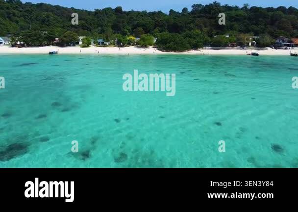 Aerial view flying towards a white sand beach on a tropical island ...