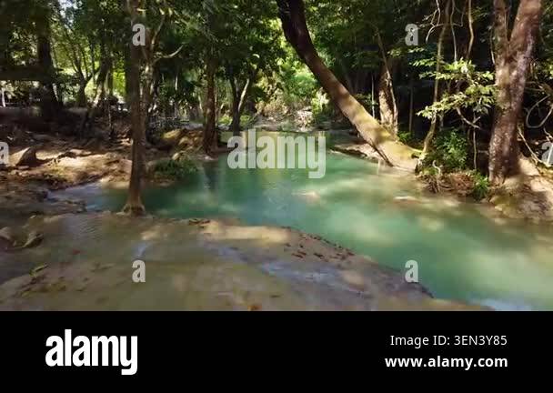 Crystal clear turquoise water flowing over rocks in a peaceful river at ...