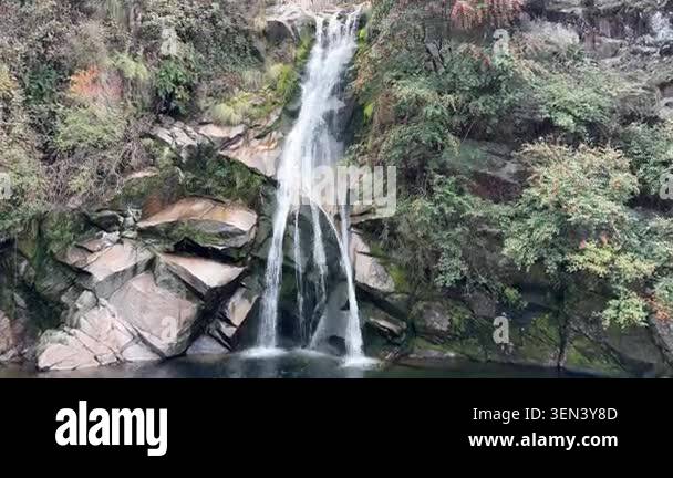 A picturesque waterfall cascading down jagged rock formations in La ...