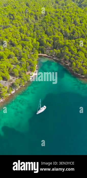 Aerial view of a white sailboat peacefully anchored in a stunning ...