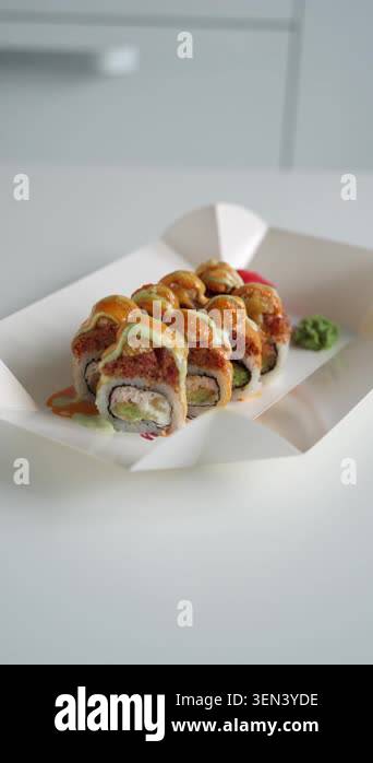 Uramaki sushi rolls with salmon, tuna and avocado, drizzled with creamy ...
