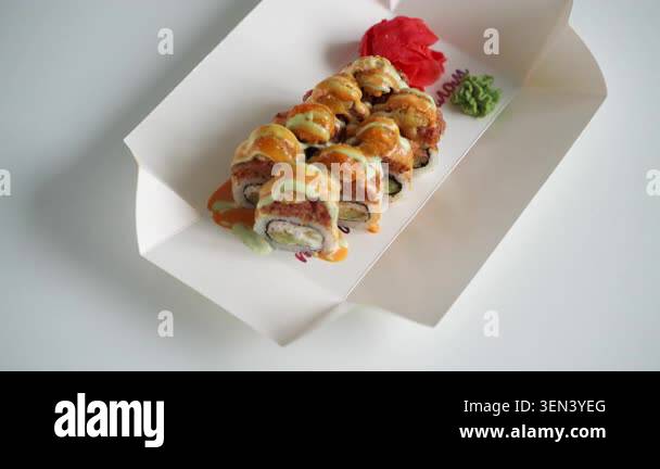 Freshly made Japanese sushi roll set drizzled with creamy sauces ...