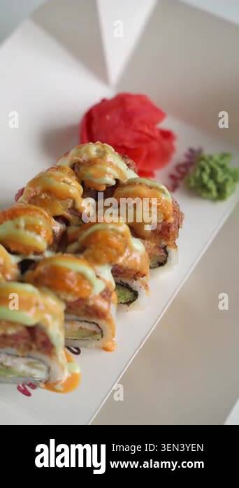 Fresh Japanese sushi rolls drizzled with creamy sauce, served with ...