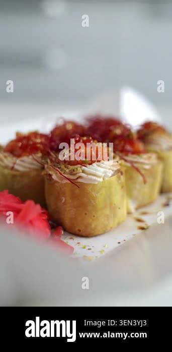 Exquisite sushi rolls topped with cream cheese and salmon tartare ...