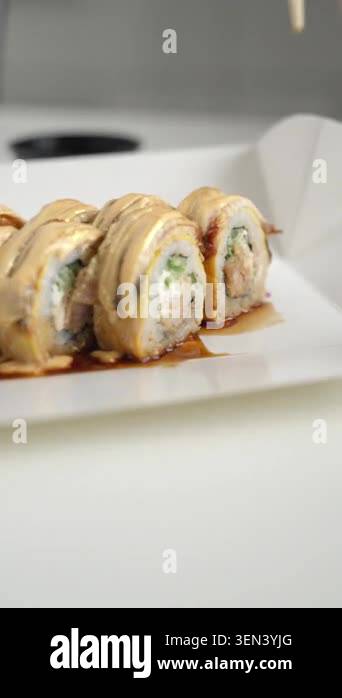 Close-up of a hand picking up a delicious uramaki sushi roll with ...