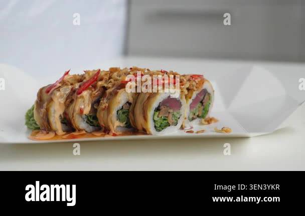 Delicious Japanese sushi maki roll with raw tuna, lettuce, spicy sauce ...