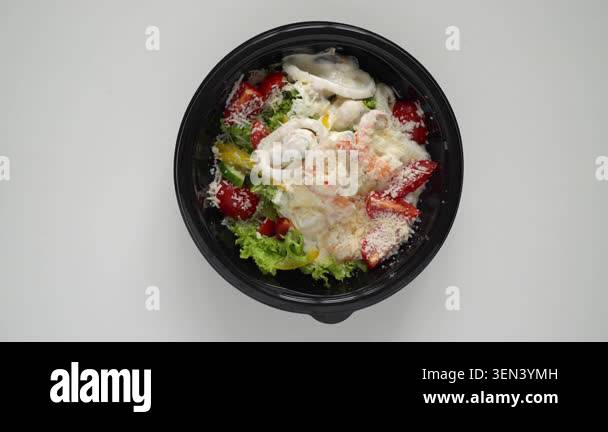 Top view of a persons hands mixing a fresh seafood salad with shrimp ...
