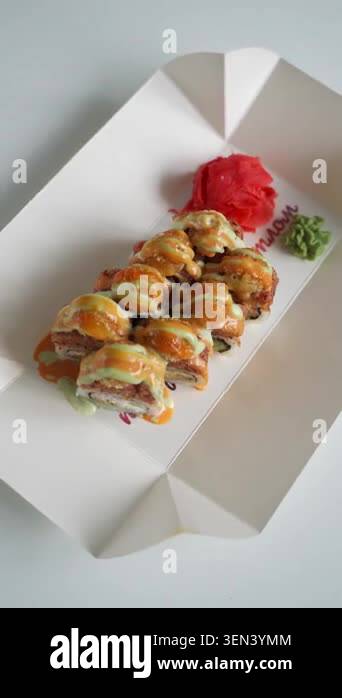 Top view of fresh Japanese baked sushi rolls with sauce, ginger, and ...