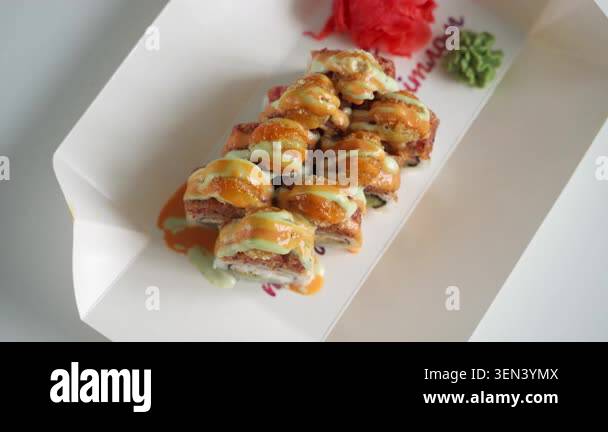 Japanese food delivery concept with a fresh set of baked sushi rolls ...