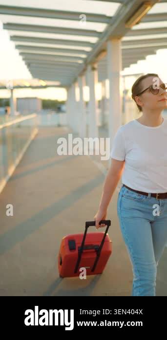 Woman travels alone. A traveler strolls through an airport terminal ...