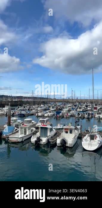 View on boats at waterfront dock on bright and sunny day. Vertical ...
