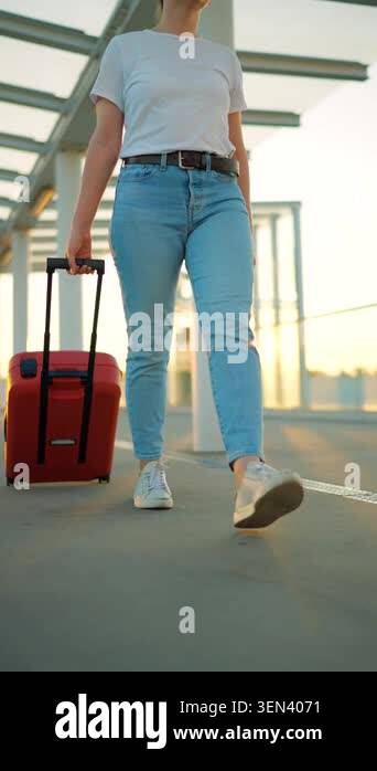 Woman travels alone. A traveler strolls through an airport terminal ...