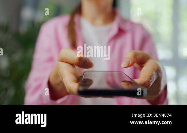 Woman scrolling through social media feeds on smartphone close up ...